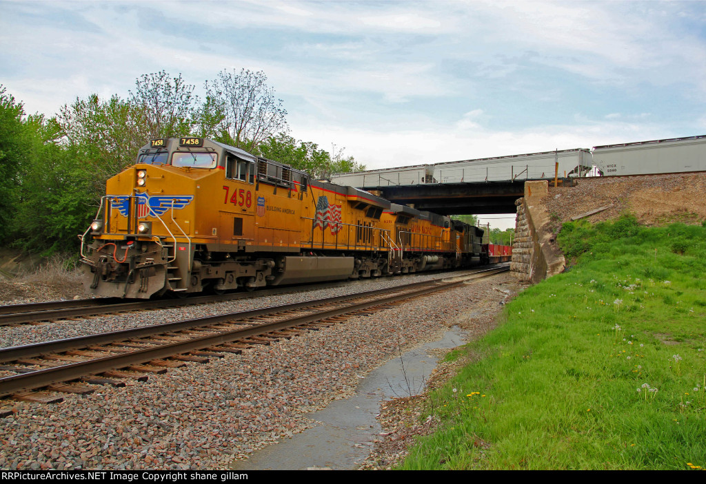 UP 7458 Leads a stack train Wb while a freight is over top.